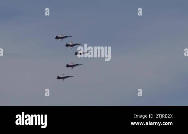 Military fighter jets of an acrobatic team flying in V formation as ...