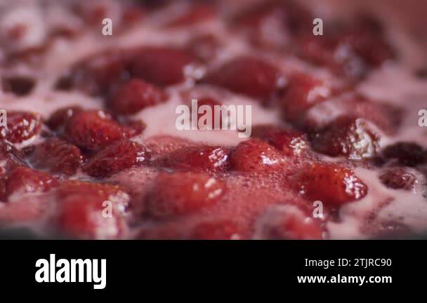 Pink foam for strawberry jam. Strawberries are boiled in a pot with ...