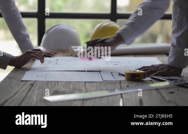 Multi-ethnic engineers, architects discuss construction plans. Engineers work on successful ...