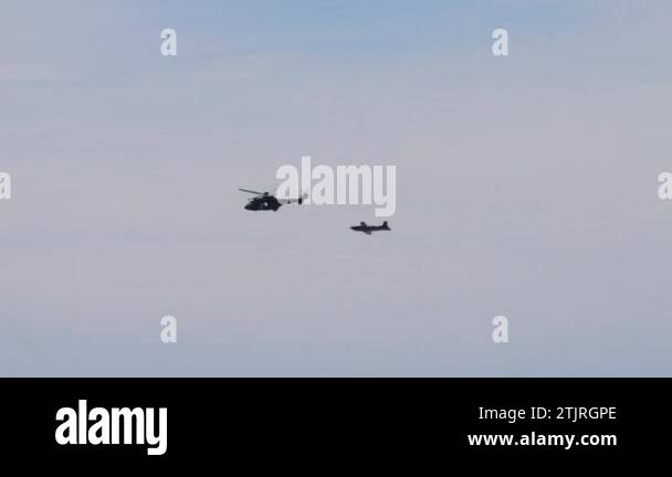 Military helicopter in flight at high speed in a narrow mountain valley ...