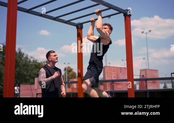 Personal fitness trainer or bodybuilder trains young athlete working ...