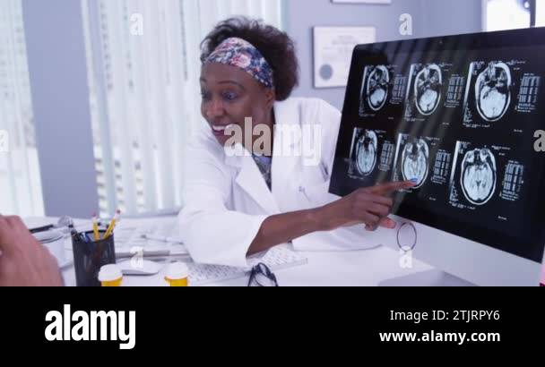 Close up of senior African doctor explaining to young patient his ct ...