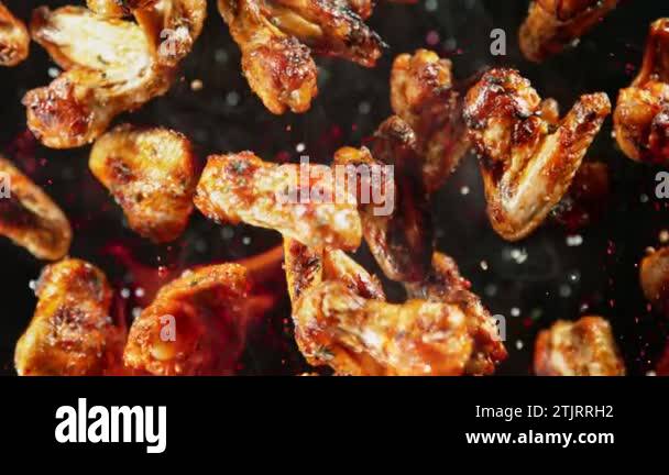 Super Slow Motion Shot of Grilled Spicy Chicken Wings Flying Towards ...
