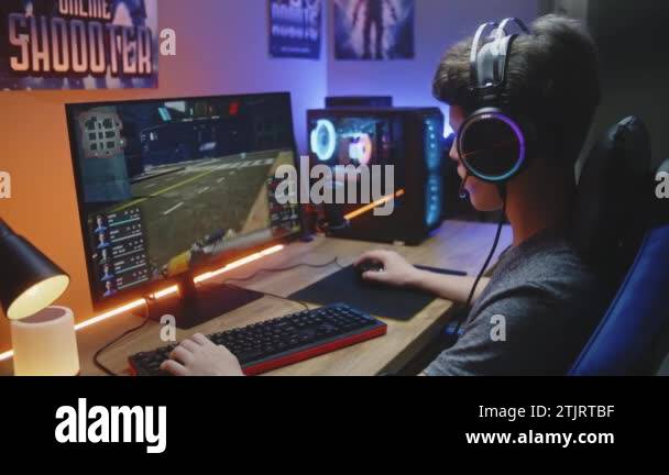 Young gamer plays in first person shooter on PC at home. Computer ...