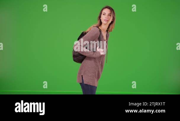 Attractive female millennial wearing backpack waiting on green screen ...