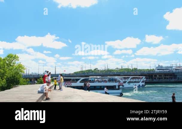 Karakoy seaside and bridge with people around, ferryboats on port ...