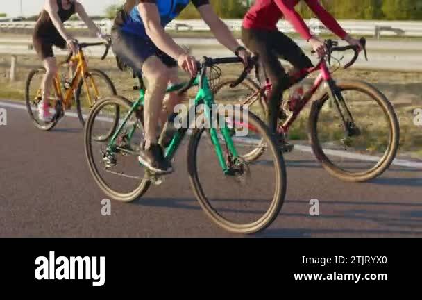 Two men and one women with muscular legs practising in cycling on ...