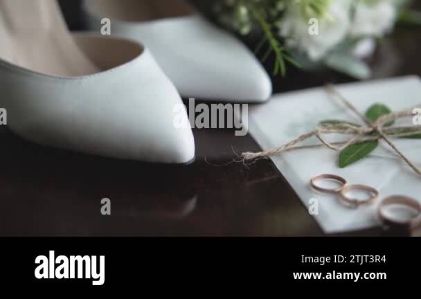 Wedding paraphernalia. White wedding shoes with a wedding bouquet. Gold ...