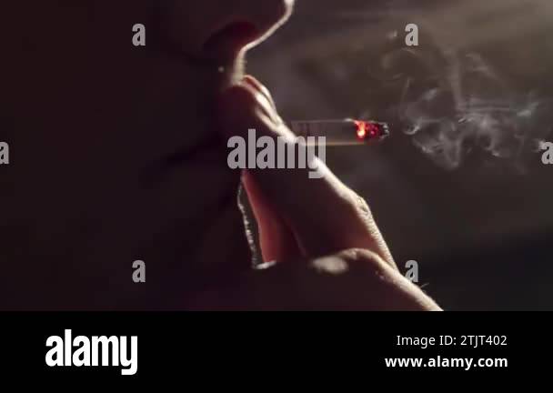 Extremely close-up, guy lit cigarette, licked his lips and released ...