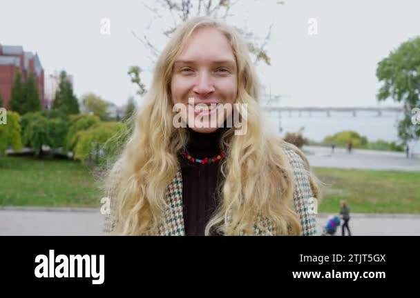 Young woman gives an interview on the street. Journalist reporting on ...