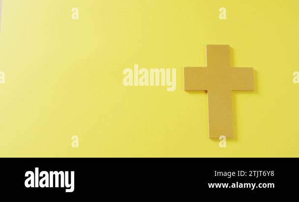 Video of brown christian crucifix cross symbol on yellow background ...
