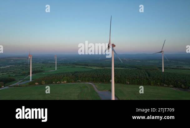 Aerial. Wind turbines standing at sunset. Aerial photo of a farm with ...