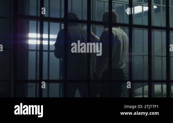 Prison guard opens jail cell with keys and locks male criminal inside ...