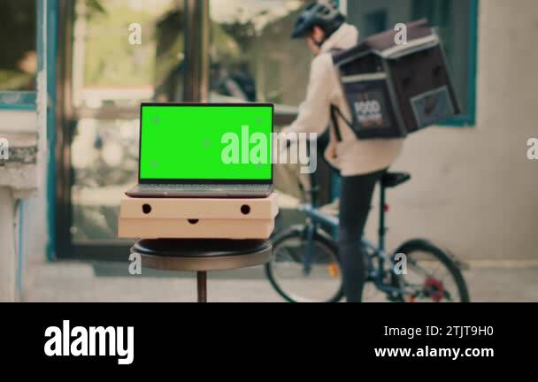 Laptop showing greenscreen display outdoors, food delivery service at ...