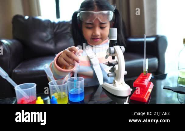 Asian little girl doing science lab experiment with liquids and ...