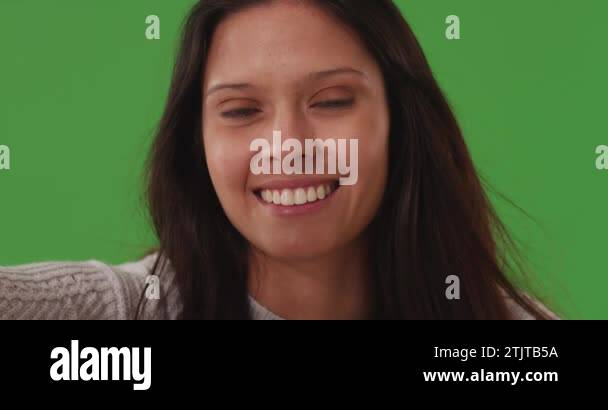 Close up portrait of attractive young lady smiling at camera on green ...