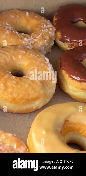 Large, open box of Tim Hortons donuts in contrasted light, with variety ...