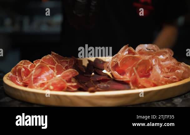 meat appetizer. food serving process. prosciutto ham and jamon cut on ...