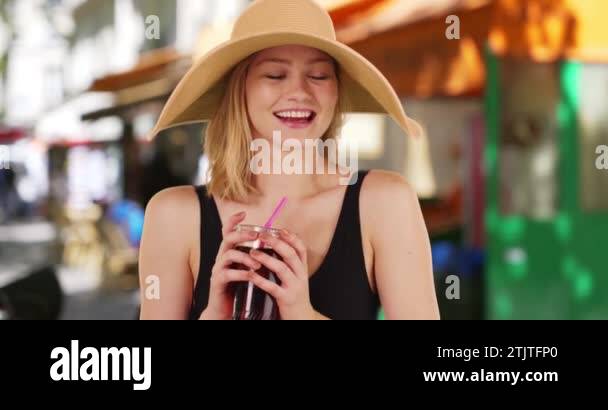 Pretty Caucasian girl in her 20s outdoors with her tea smiling. Happy ...