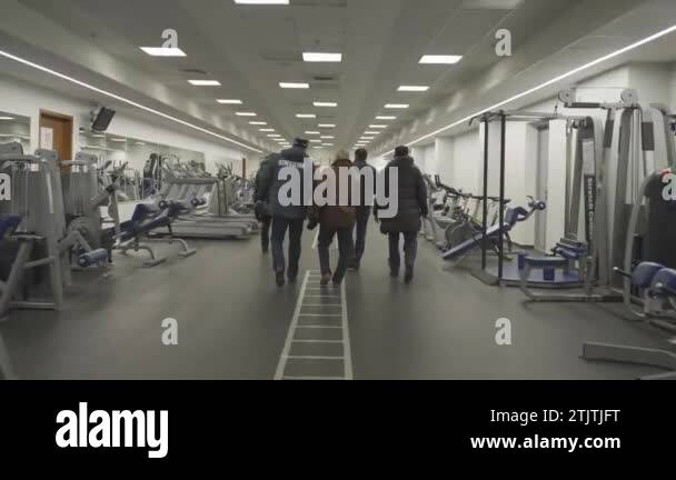 Hockey team professional trainers walking with guide along ice arena ...