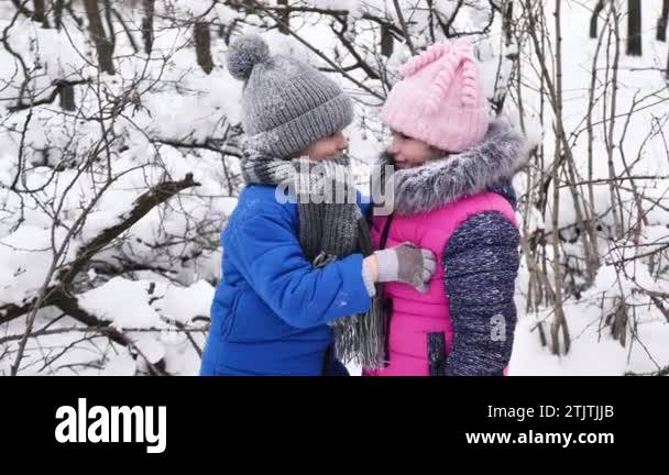 Children, a boy and a girl, hug and kiss in the winter in the cold in ...