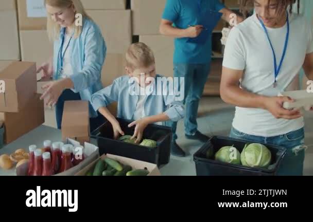 The Concept of Social Aid: Cute Young Boy Help to Volunteers to Sorting ...
