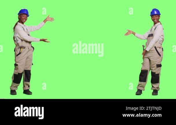 Smiling builder advertising something on full body greenscreen ...