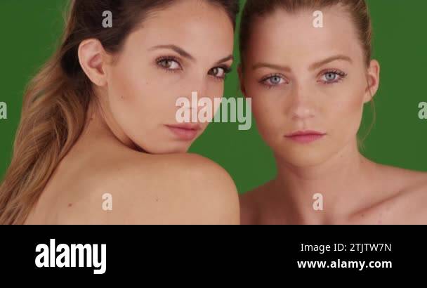 Attractive young models posing in make-up on green screen. Two young ...