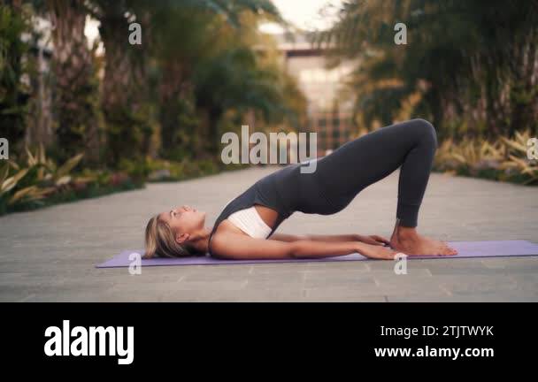 Fitness workout in scenic tropical garden. Young woman working on her ...