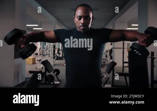 Black man workout with dumbbell training shoulders in gym.Bodybuilder ...