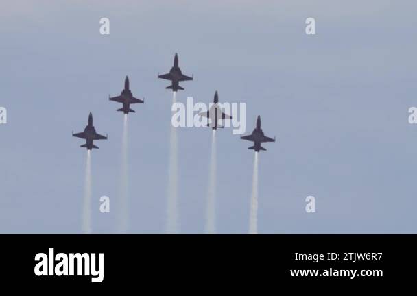 Acrobatic team looping in V formation backlight with smoke and flares ...