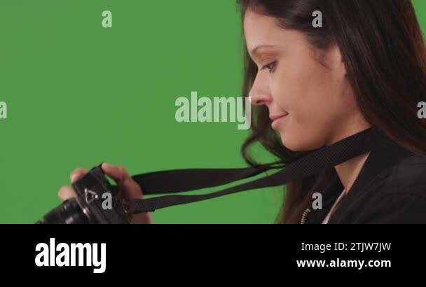 Profile view of attractive female photographer using dslr camera to ...