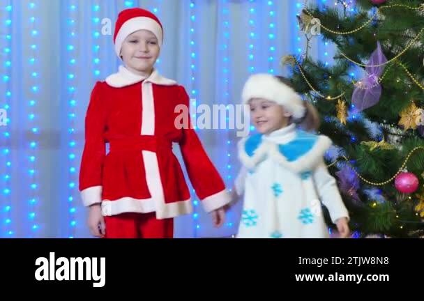 Brother and sister in Christmas costumes of Santa Claus and Snow Maiden ...