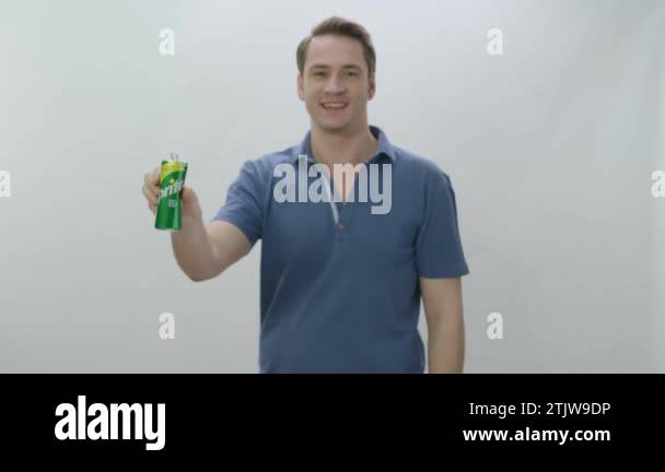 Young man drinks fizzy Sprite beverage from metal bottle. Slow motion ...