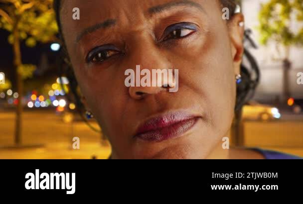 Older African American woman on Paris street at night looking sadly ...