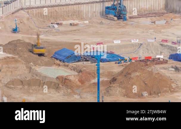 Pile driving in foundation pit for construction of apartment complex building aerial timelapse ...