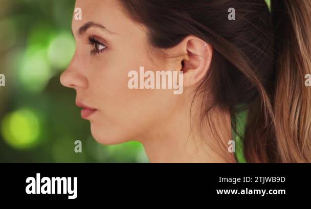 Close-up profile of beautiful model turning head towards camera in ...