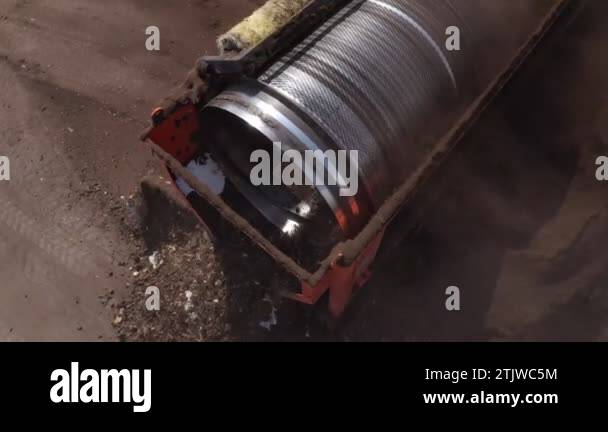 Industrial compost production site. Machines screening compost piles ...