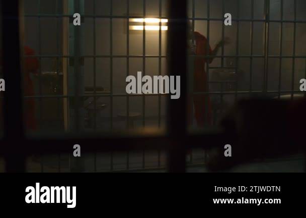 One angry female prisoner in orange uniform yells at neighbor inmate ...