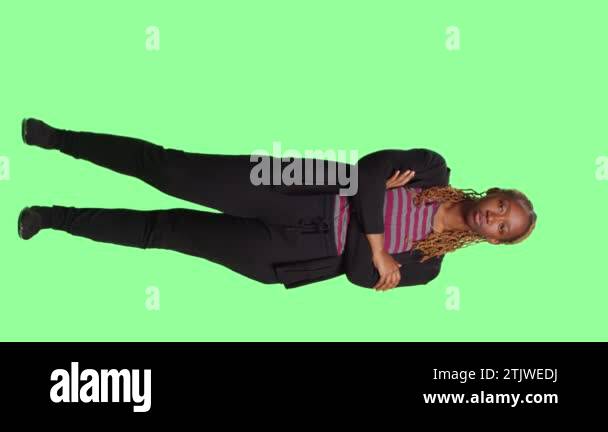 Vertical video: African american woman posing on greenscreen backdrop ...