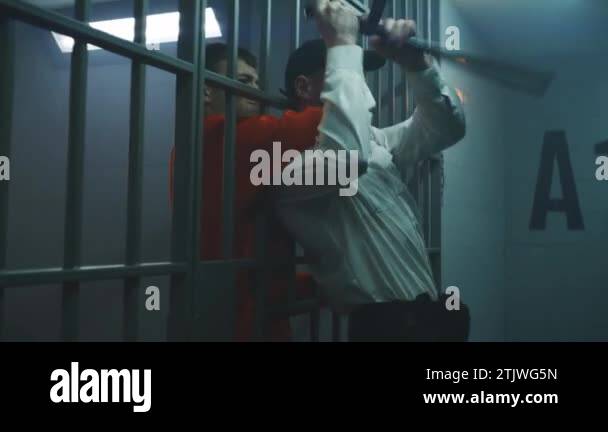 Cinematic shot of male prisoner strangling prison officer, taking keys ...