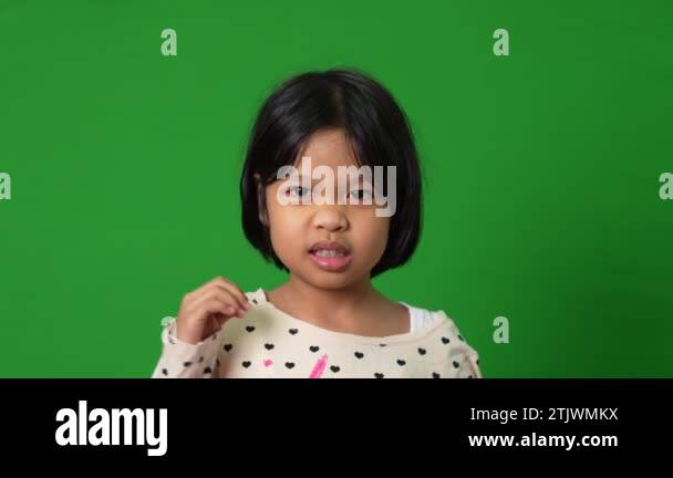 Portrait of Asian angry and sad little girl on green screen background ...