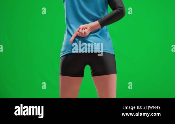 Back view of female volleyball player showing finger gestures on green ...