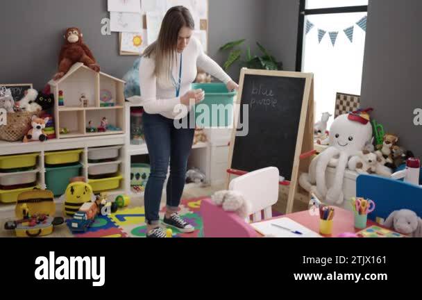 Young pregnant woman preschool teacher collecting toys suffering ...