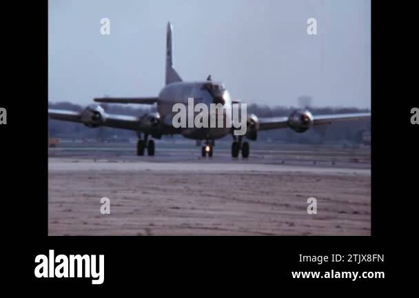 Heavy-lift military cargo aircraft of 60s taxiing slowly on the runway ...