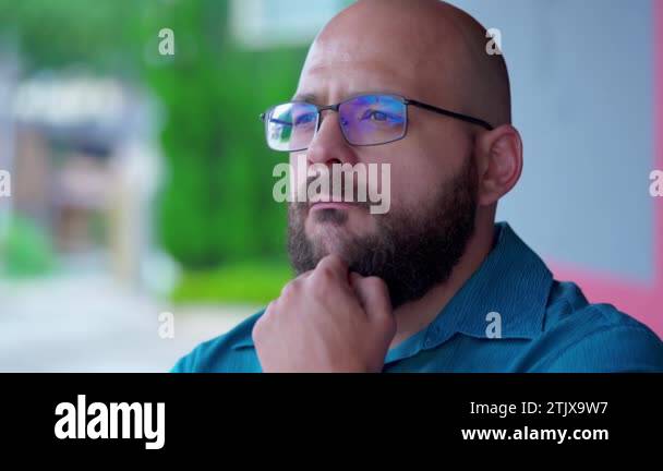 Contemplative man thinking deeply with hand in chin, touching beard ...