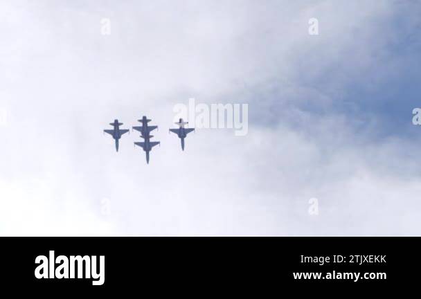 Fast jet planes performing a barrel roll in a narrow mountain valley ...