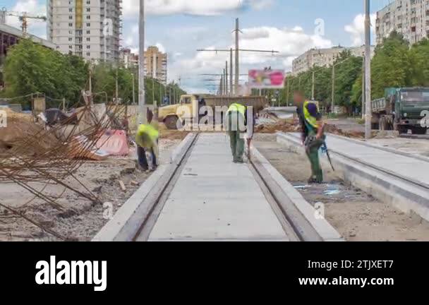 Workers do cleaning of the railway tram line after construction works ...