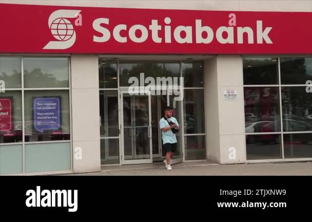 scotiabank store with customer pedestrian exiting, cars and traffic ...