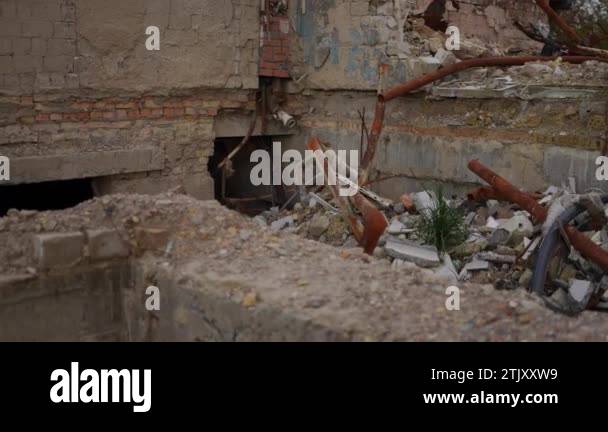 Live camera panning along ruined utilities pipes in bombed destroyed ...